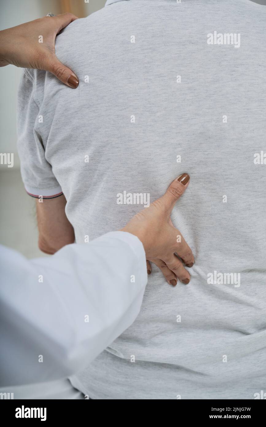 Doctor checking back and spine of male patient Stock Photo - Alamy