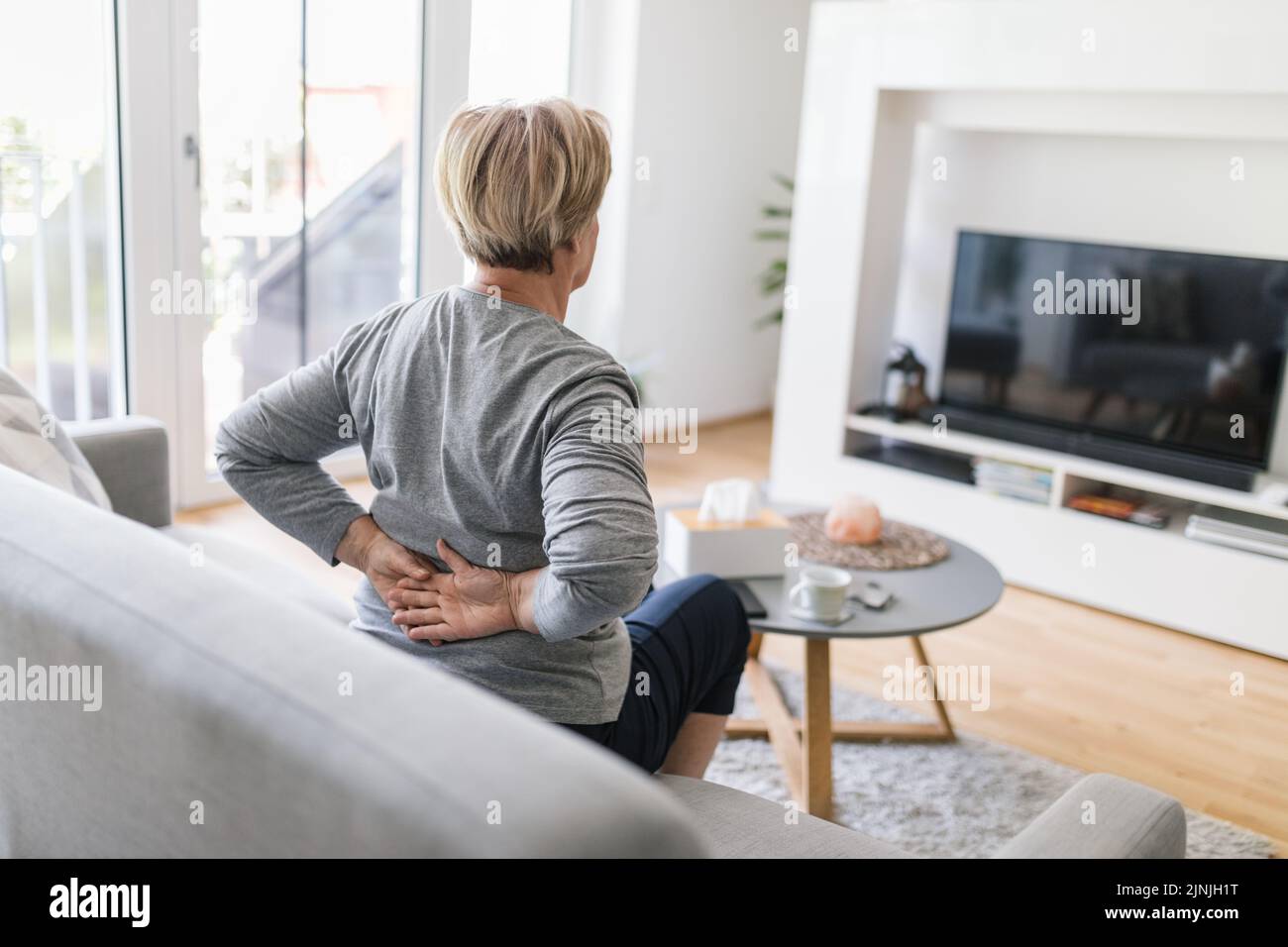 Elderly woman at home with lower back pain Stock Photo - Alamy