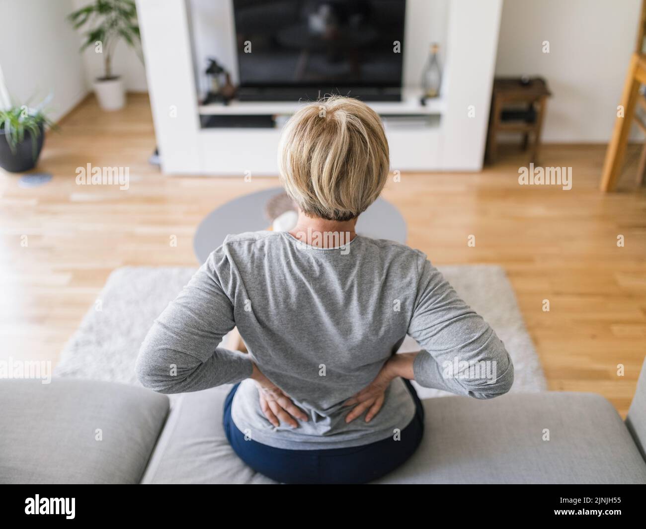 Elderly woman at home with lower back pain Stock Photo - Alamy