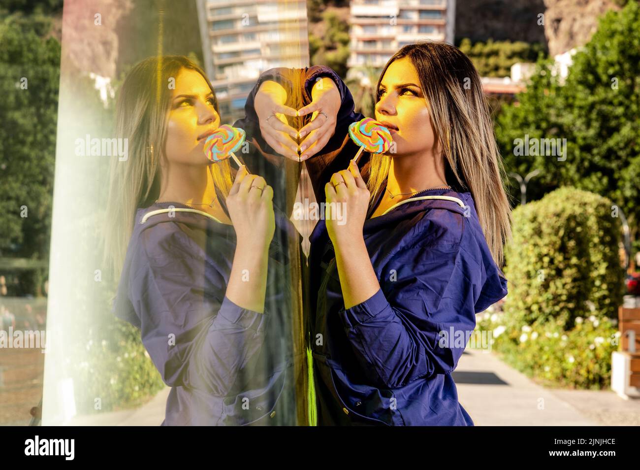 A Young woman with a purple sweater and a colorful candy lollipop near ...