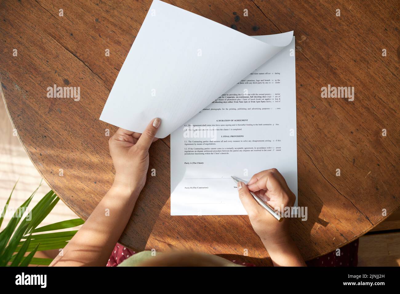 Directly above view of unrecognizable businesswoman studying contract ...
