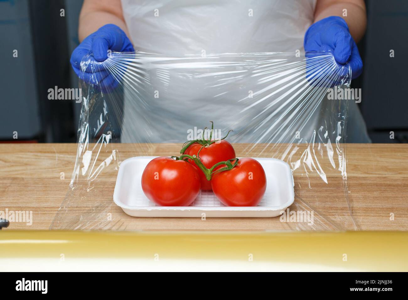 Grocery retailers. Packing of food products. Unknown worker in blue ...