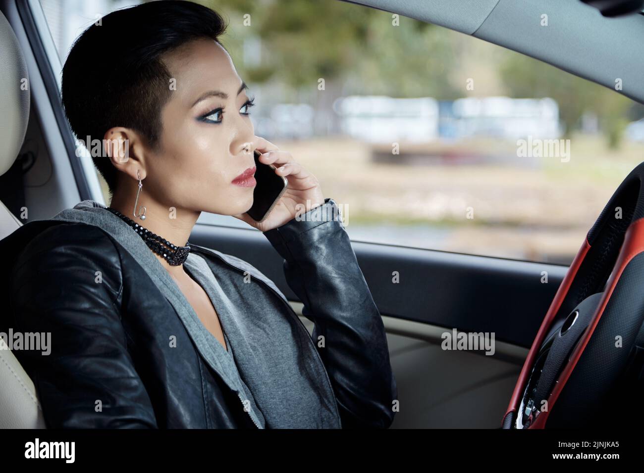 Vietnamese female driver talking on the phone Stock Photo - Alamy