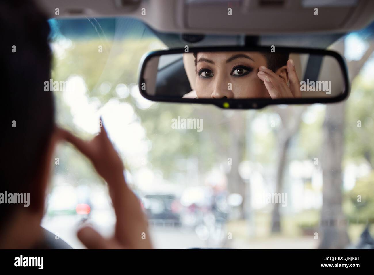 Beautiful Vietnamese female driver looking at rear view window Stock ...