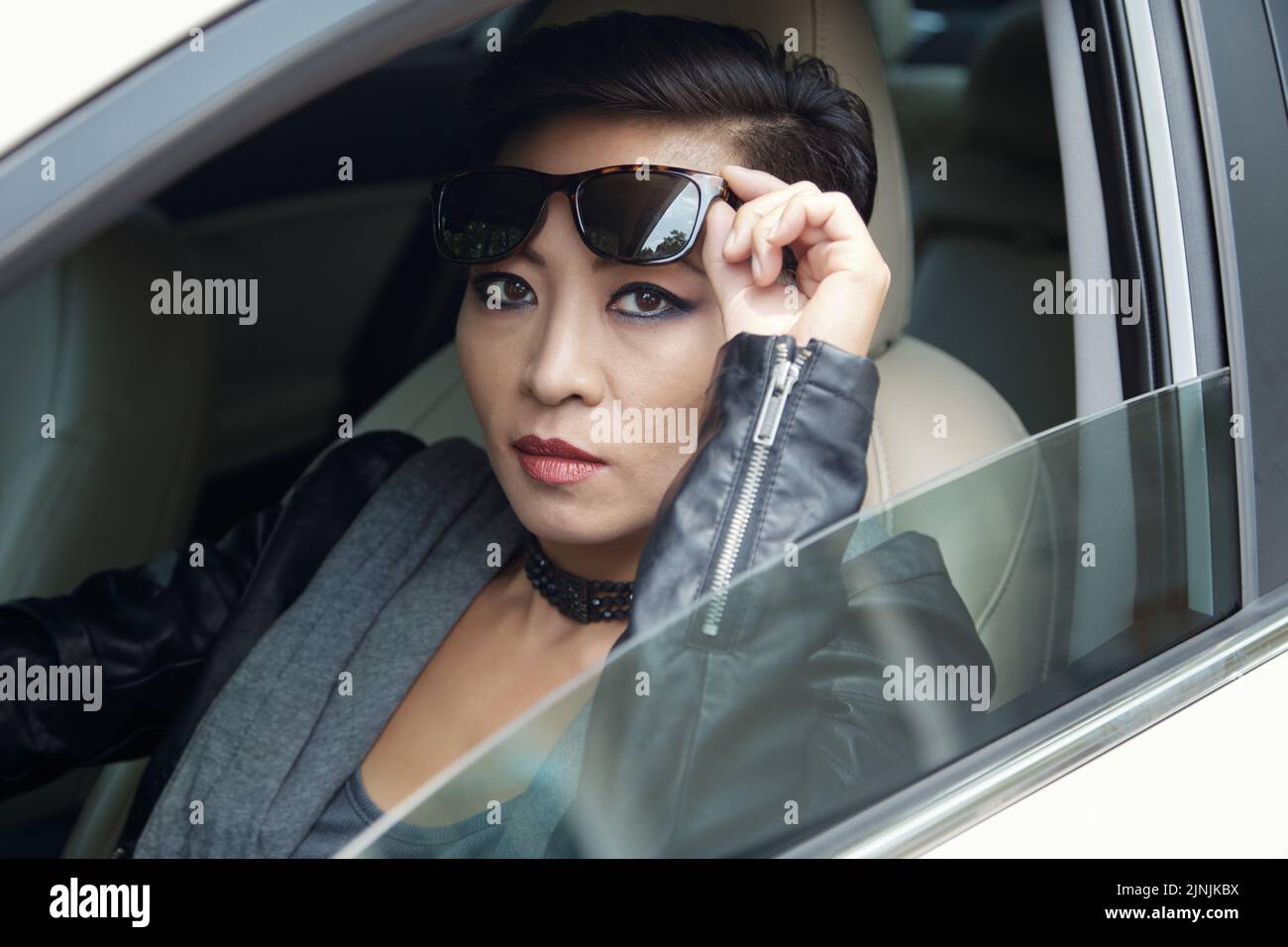 Vietnamese female driver looking out of her sunglasses Stock Photo - Alamy