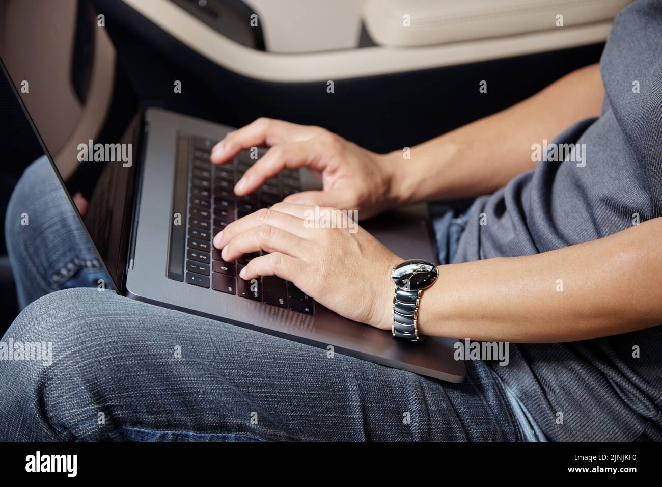 Hands of woman sitting in car and working on computer Stock Photo - Alamy
