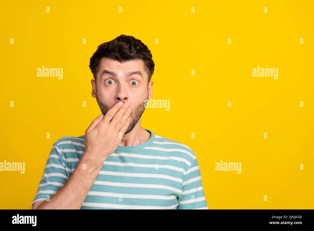 Closeup photo of young attractive guy hold hand closed mouth unexpected ...