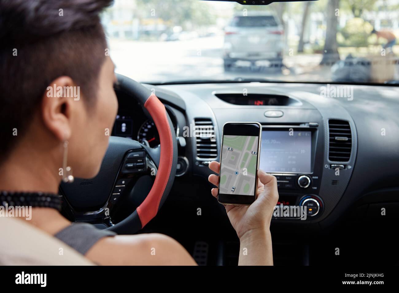 Woman checking navigation application when driving car, view over the ...