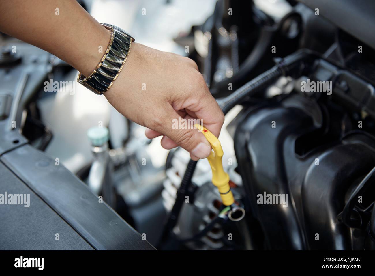 Car mechanic checking oil level in car engine Stock Photo - Alamy