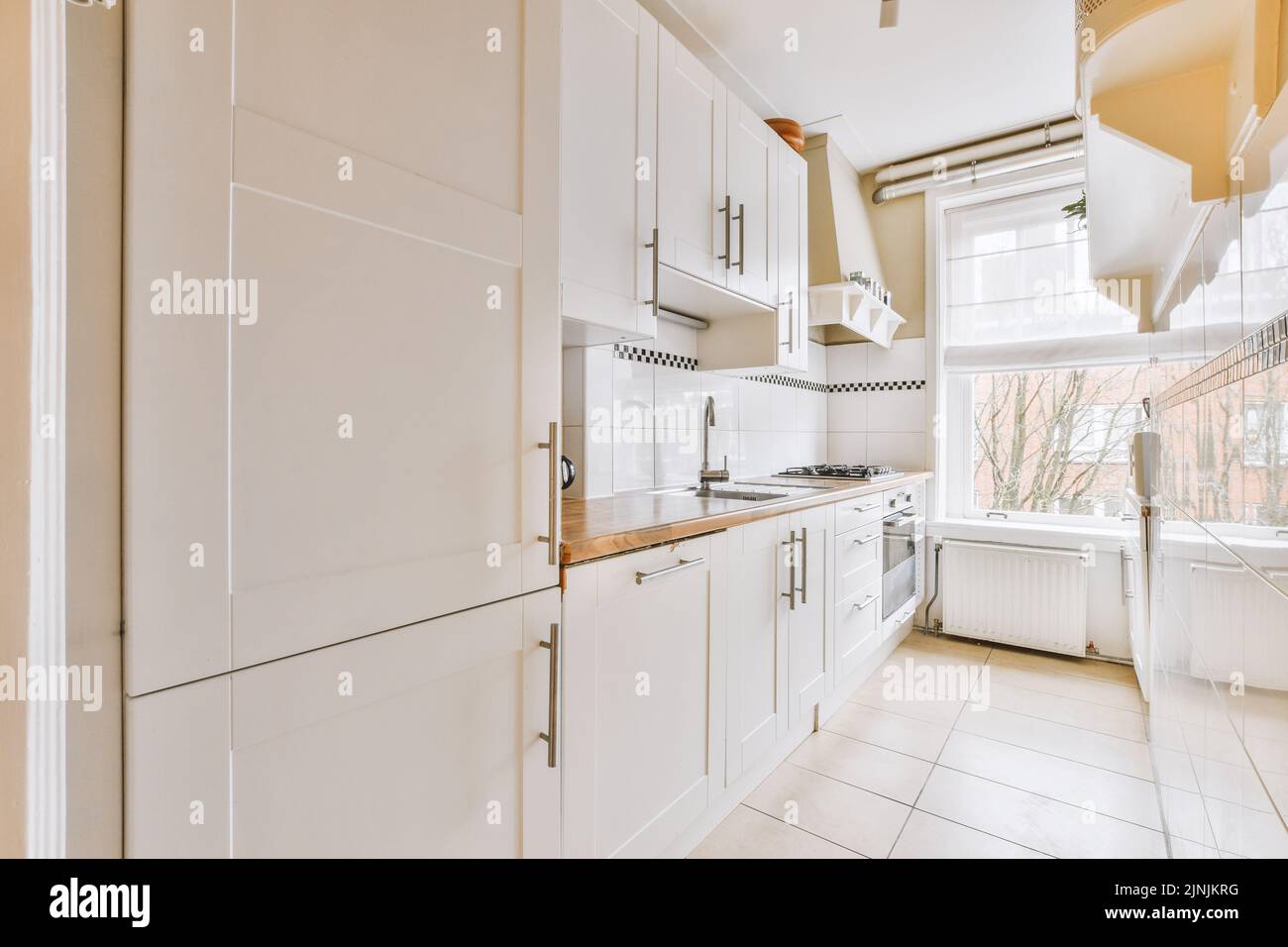 Fragment of interior of light narrow home kitchen with minimalist style ...