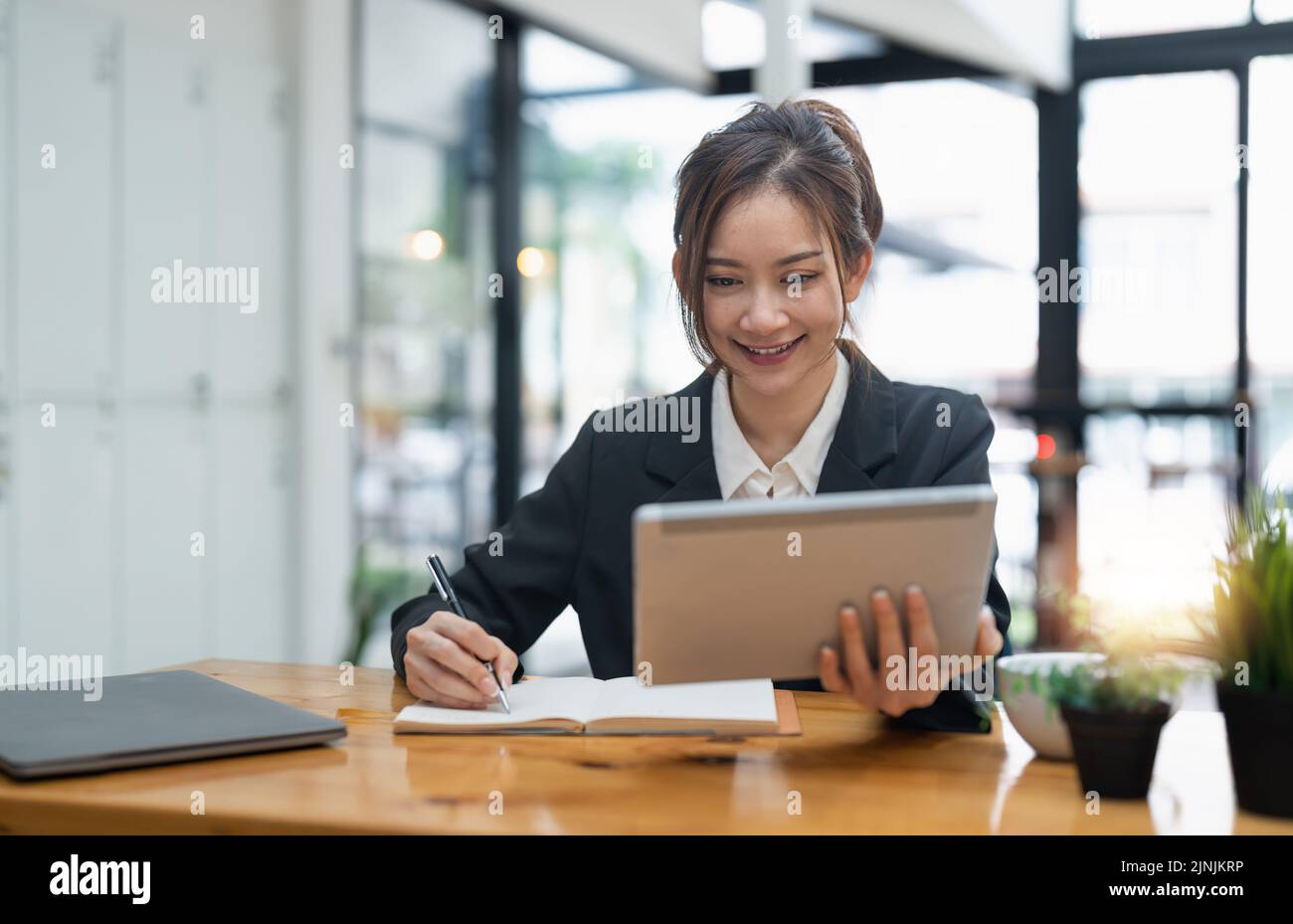businesswoman using digital tablet and pen to take notes at office ...