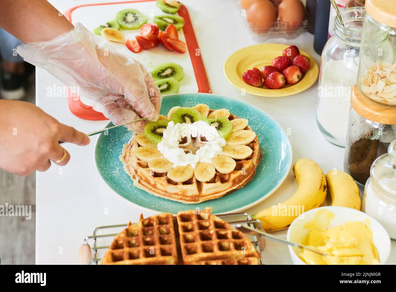 Cook putting fresh fruits on cooked waffles Stock Photo - Alamy