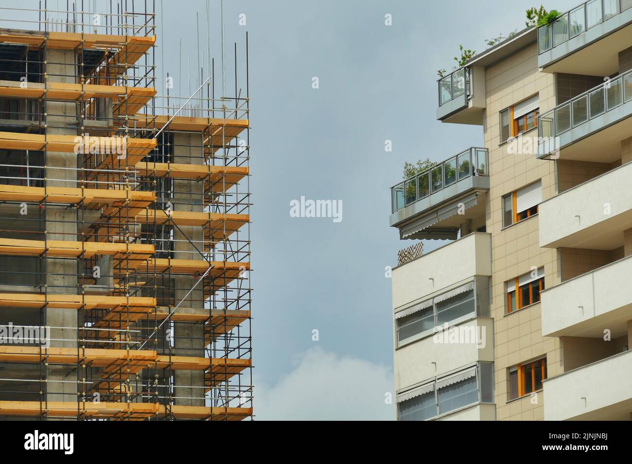 An unfinished building by a newly built building Stock Photo - Alamy