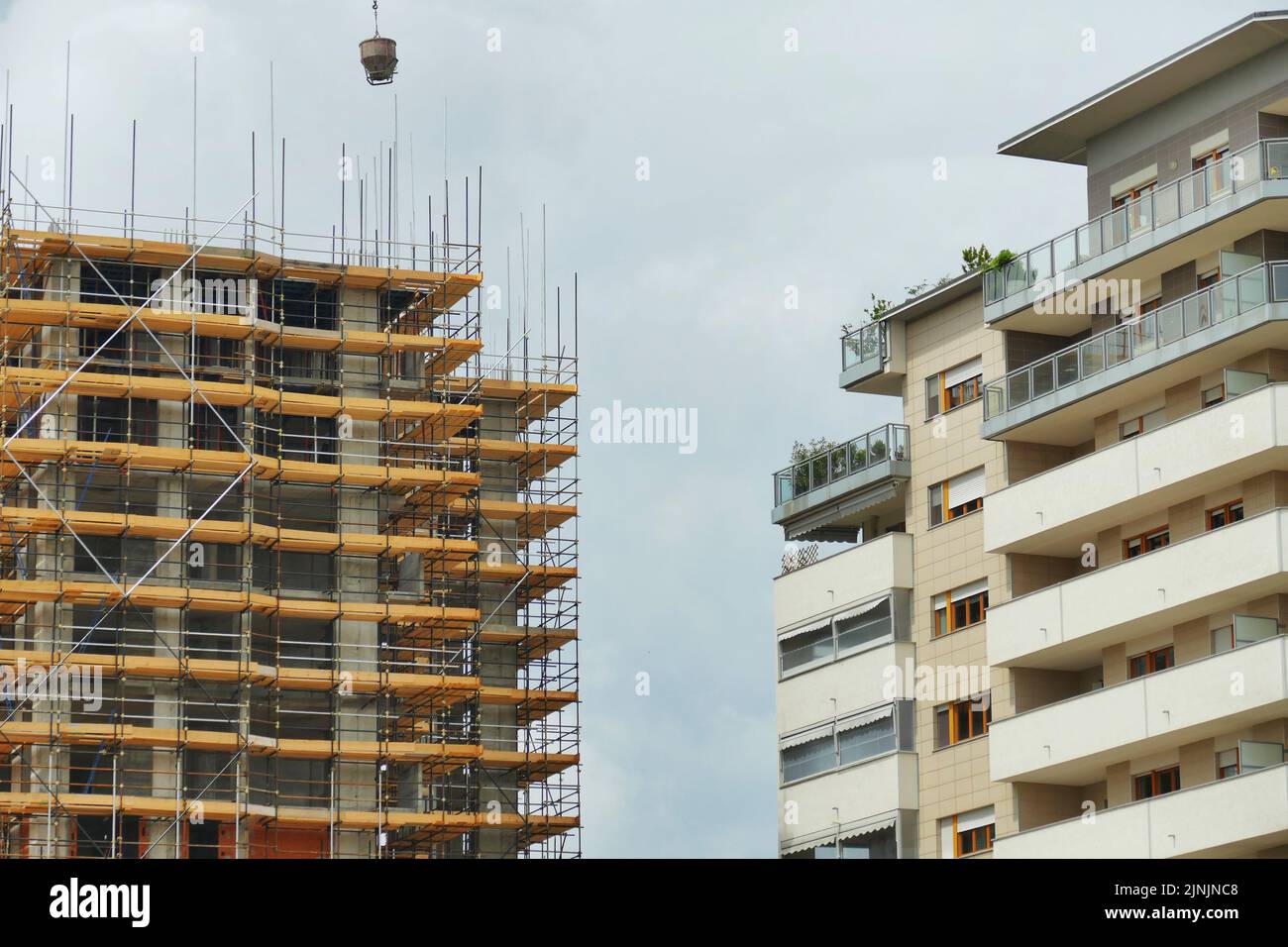 An unfinished building by a newly built building Stock Photo - Alamy
