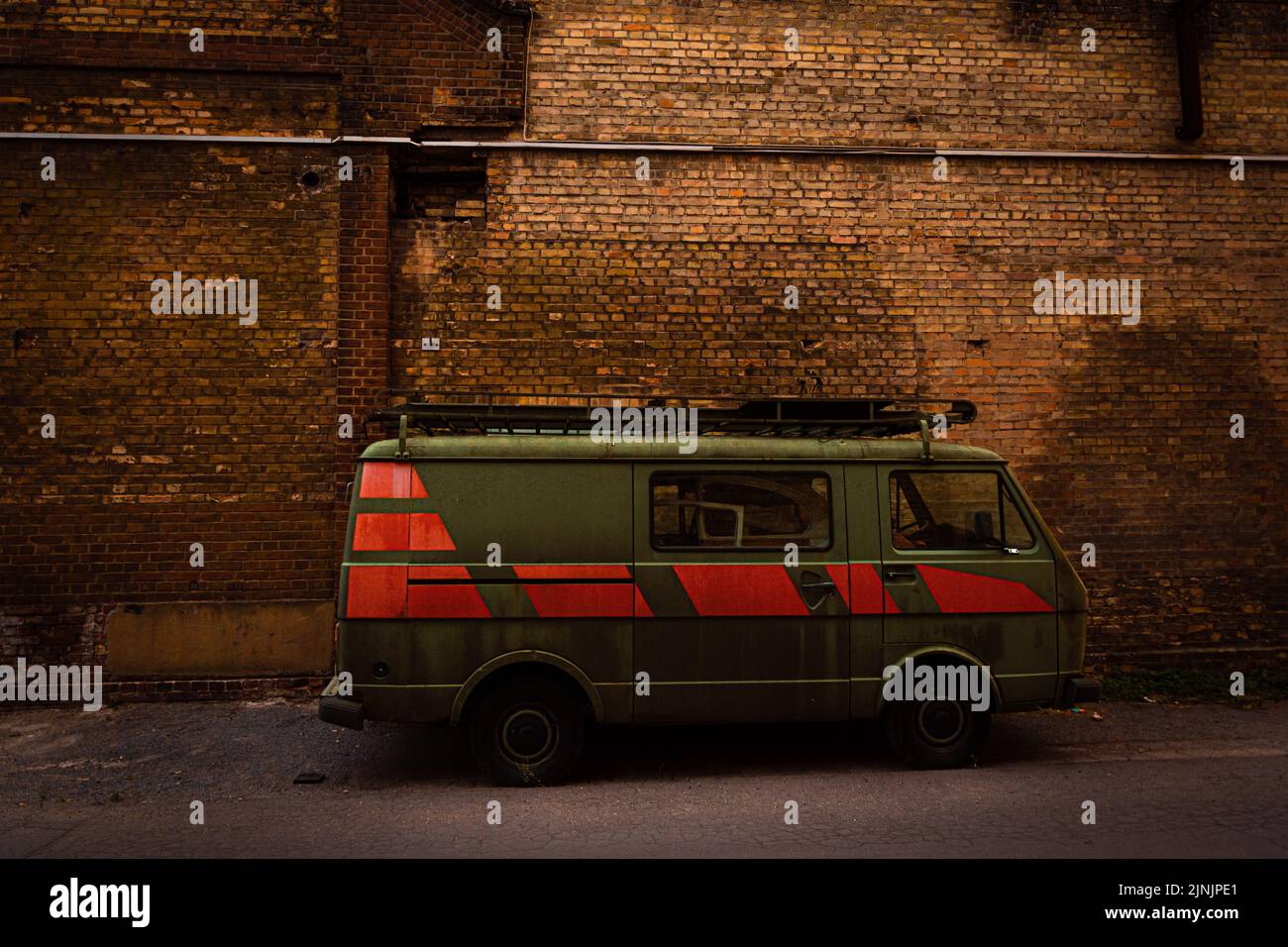 Old bus in front of an industrial wall Stock Photo - Alamy