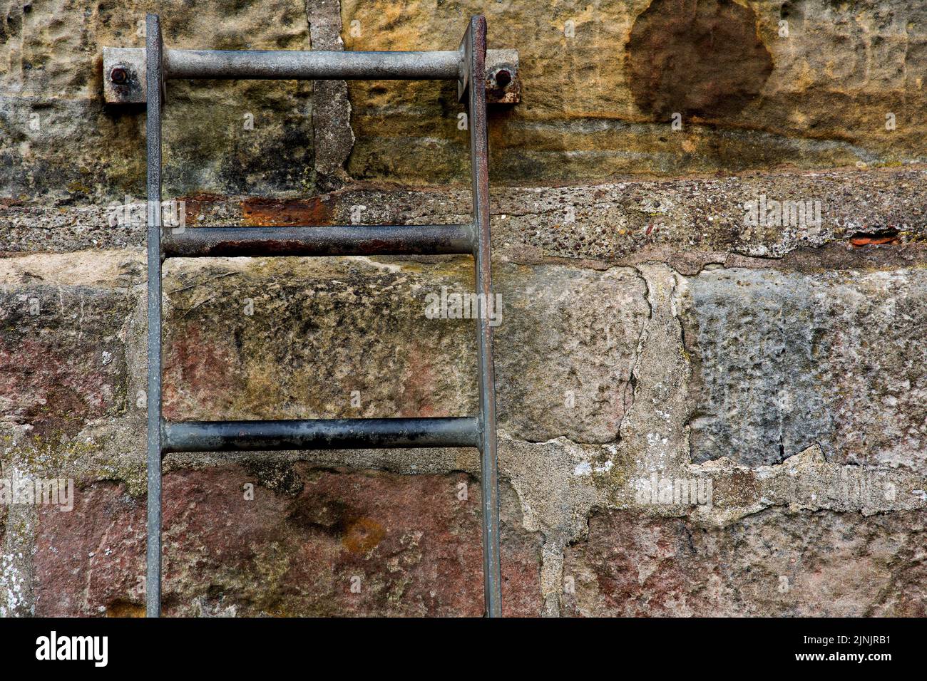 Old access ladder bolted to a harbour wall Stock Photo - Alamy