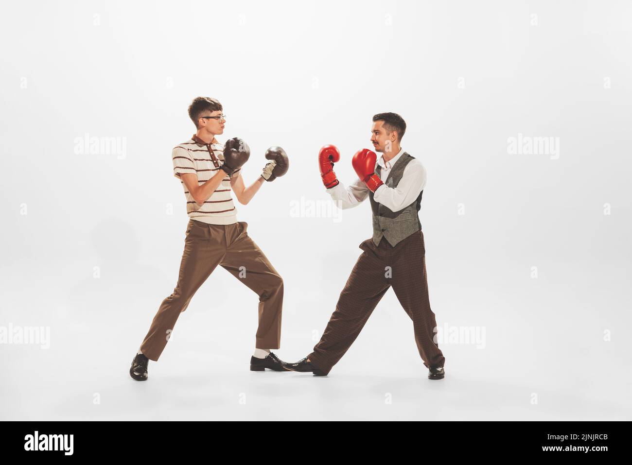 Portrait of two men in retro clothes, suits fighting for fun, boxing ...