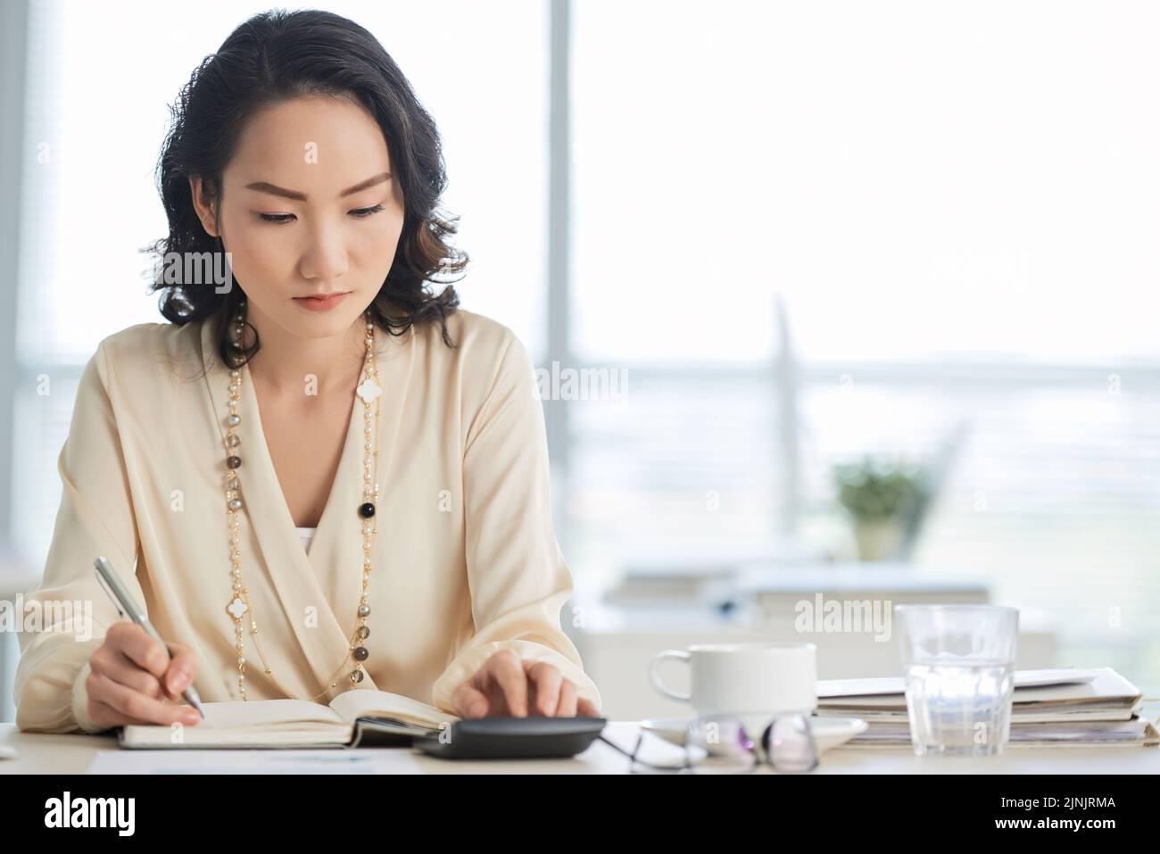 Pretty Chinese business woman busy with work Stock Photo - Alamy