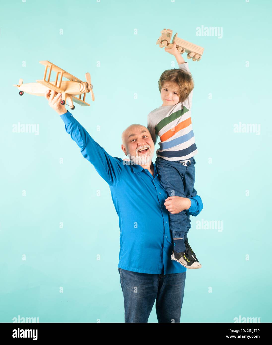 Grandson child and grandfather piggyback with toy plane and wooden ...