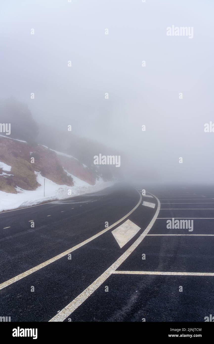 mountain road with snow and thick fog. Parking at the mountain pass ...