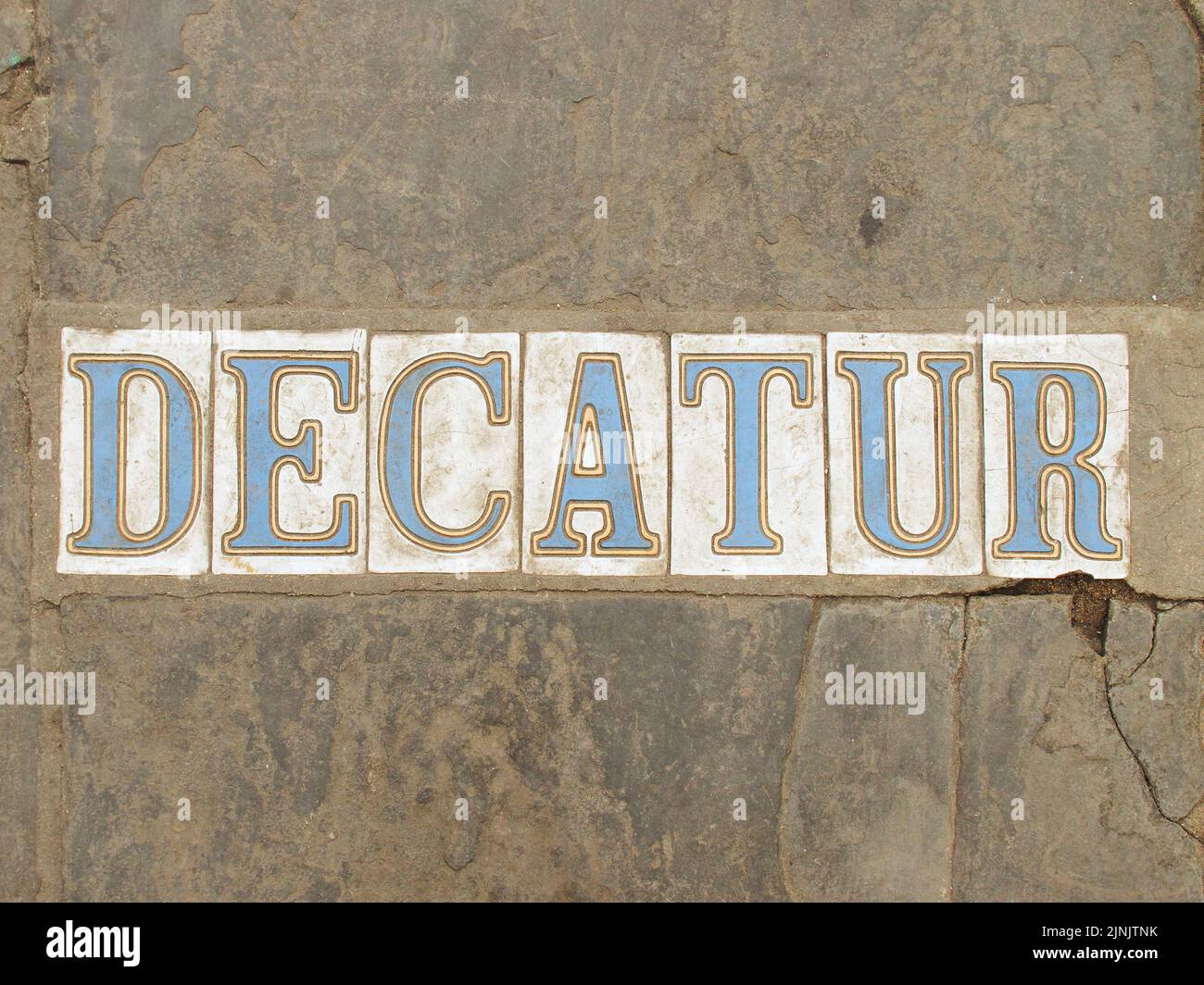 The Decatur Street tile sidewalk marker in blue and yellow letters in ...
