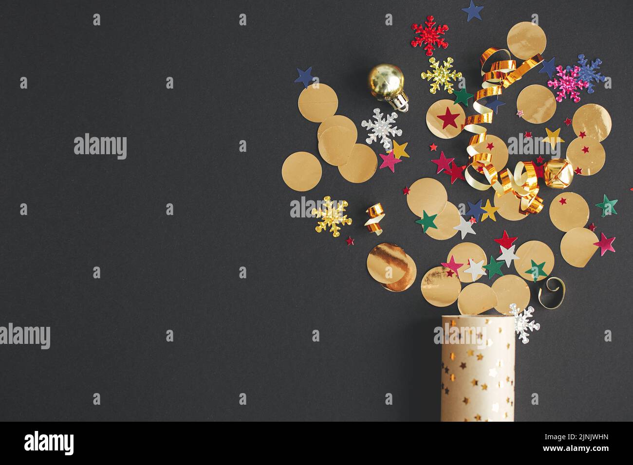 Modern colorful confetti popping from golden wrapping paper on black ...