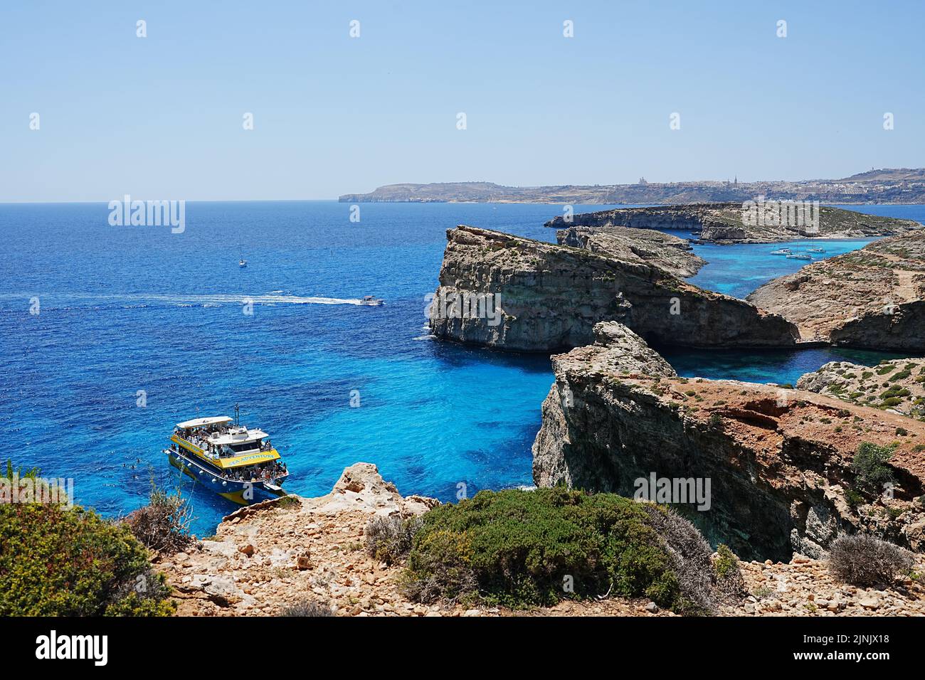 Tourist boat on crystal lagoon in european Comino island in Malta ...