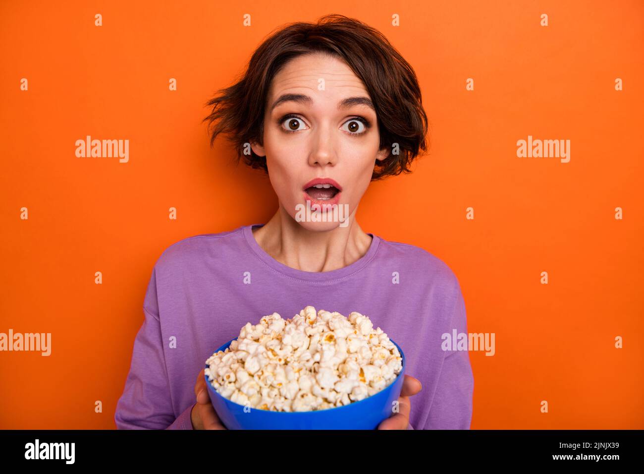Photo of impressed nice lady hold big plate popcorn open mouth look ...