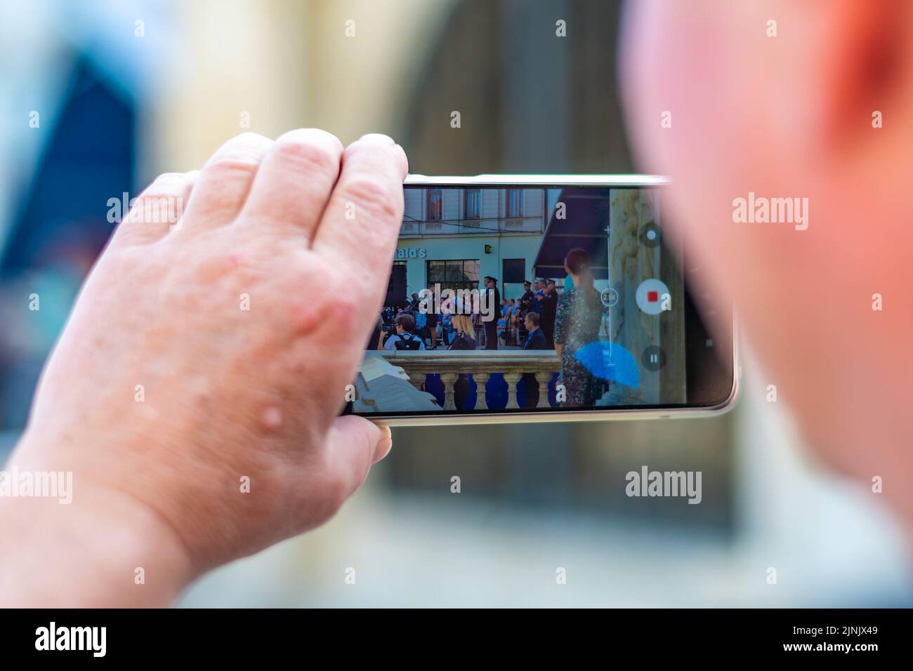 Brno, Czech Republic - 10.9.2021: Old man is taking photo via cell ...