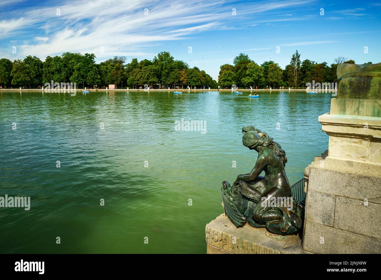 Lago del Retiro in Madrid with Roman statues and boats sailing on the ...