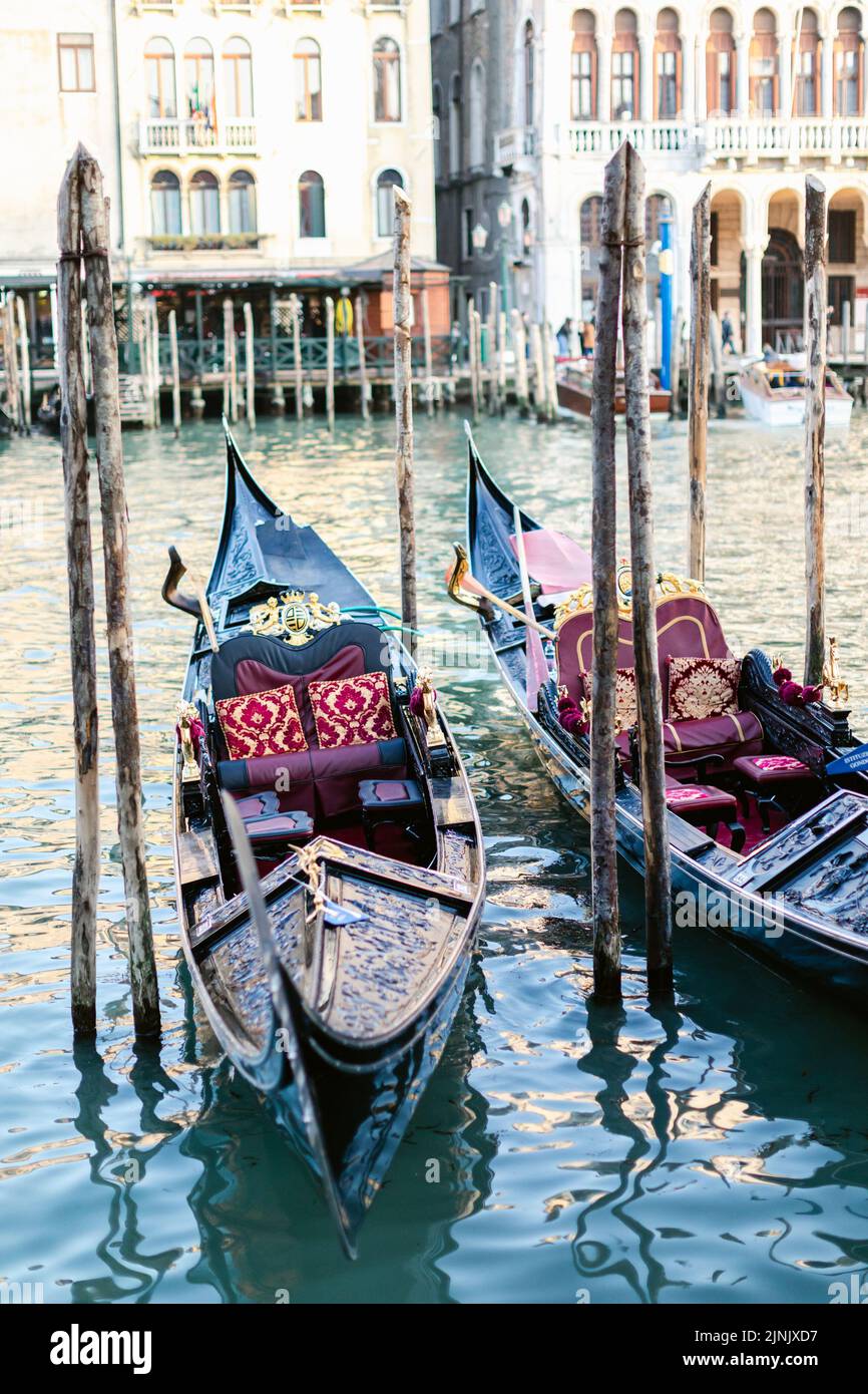 A vertical shot of two gondolas with ornaments on a channel in Venice ...