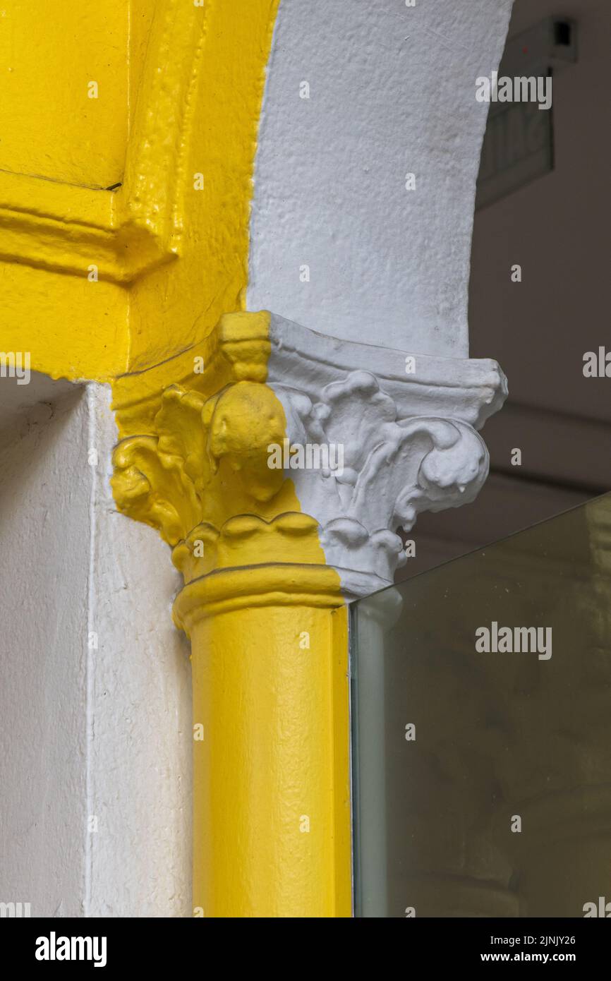 A view of the column of a white building with yellow paint Stock Photo ...