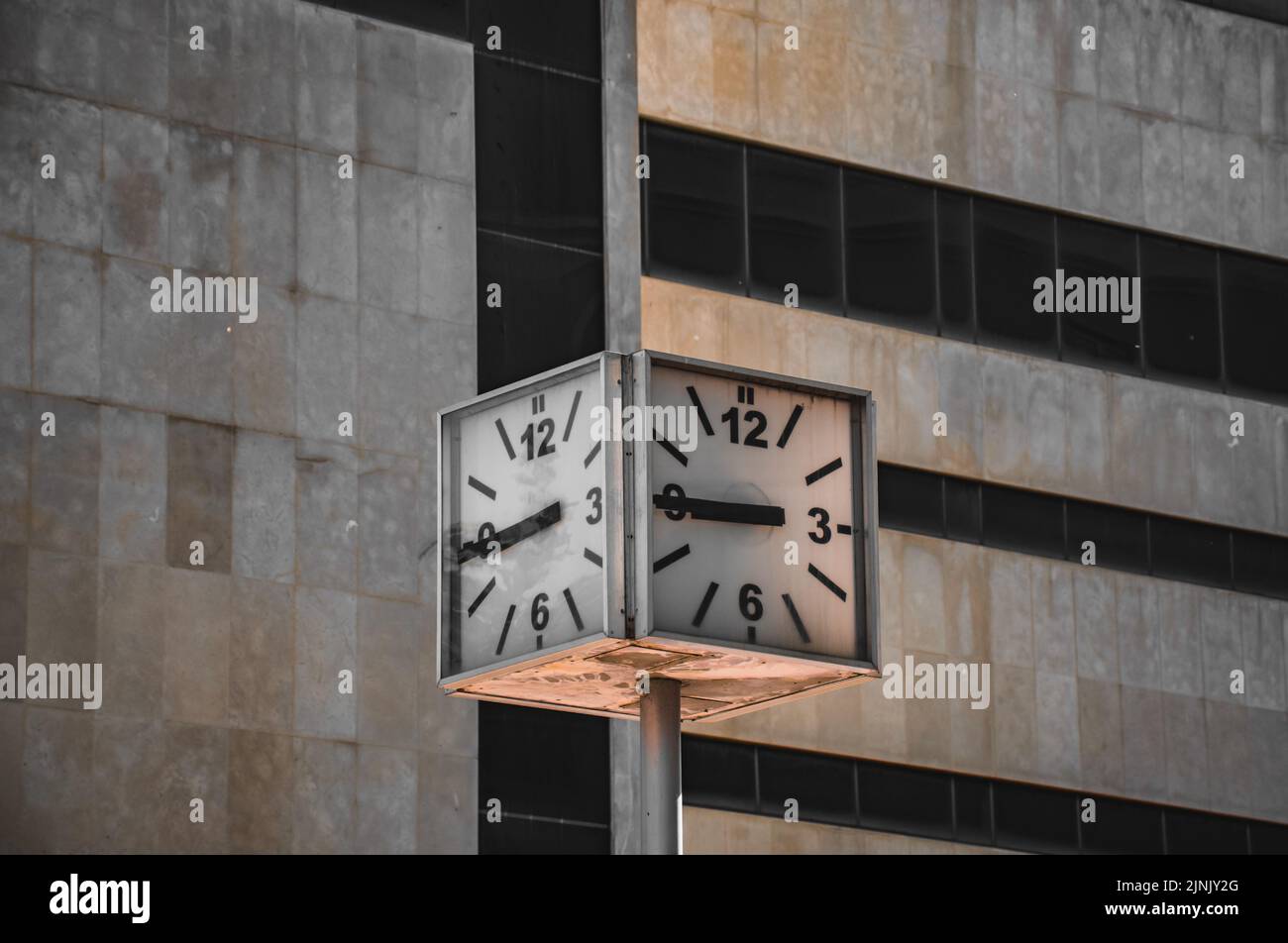 A view of a clock on a pole with modern buildings in a background Stock ...