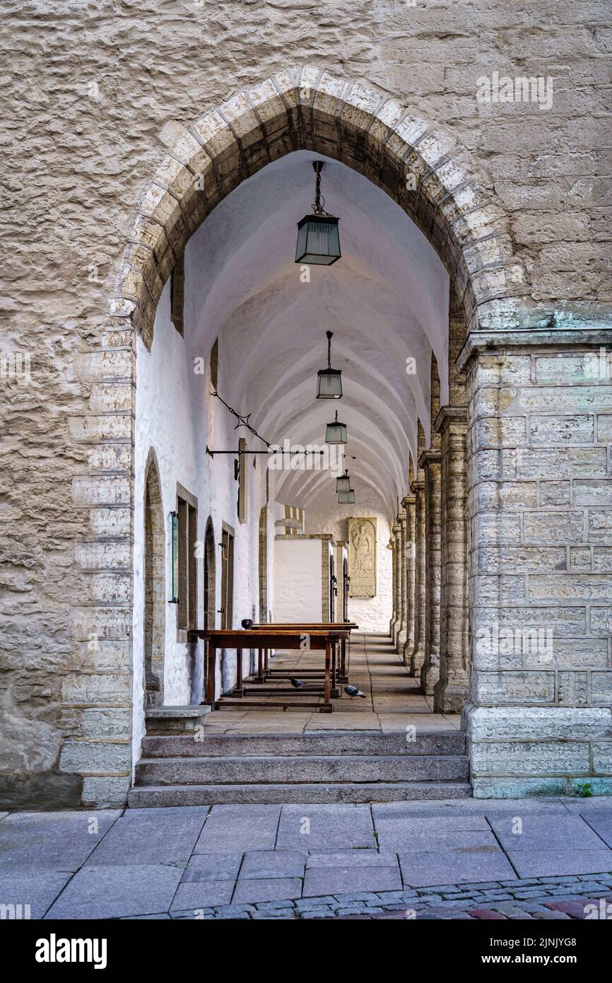 Passageway under a medieval building with arches and stone walls ...