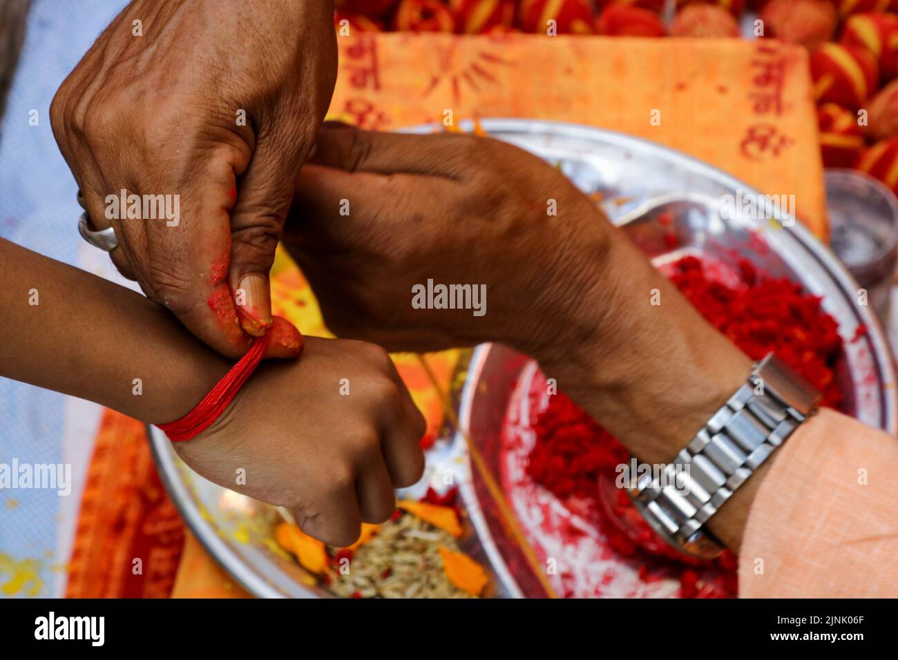 Kathmandu, Nepal. 12th Aug, 2022. A priest ties holy sacred thread on ...