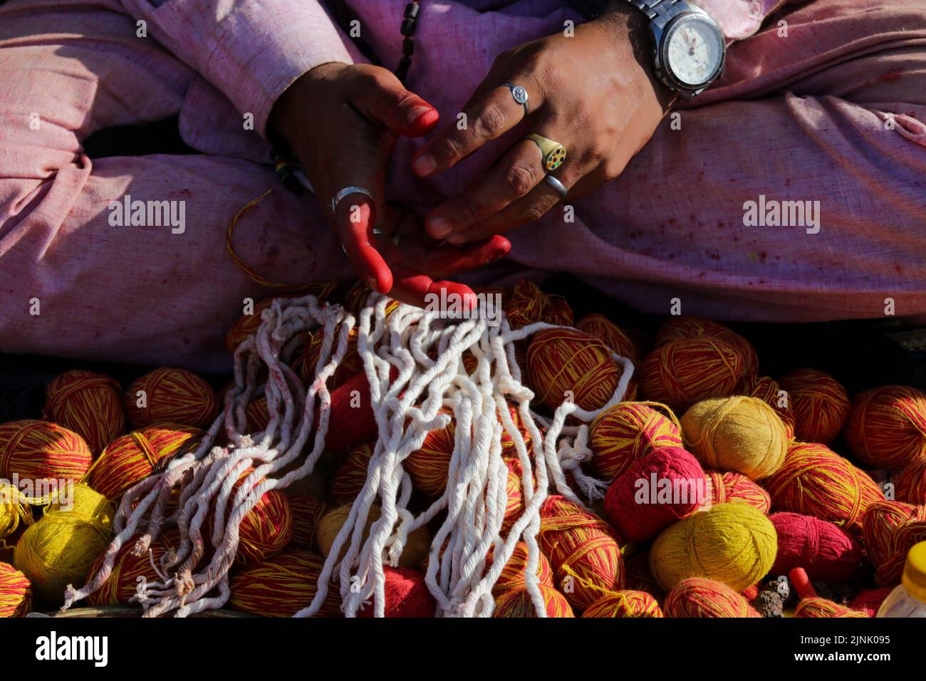 A priest surrounded with holy sacred thread waits to tie it in the ...
