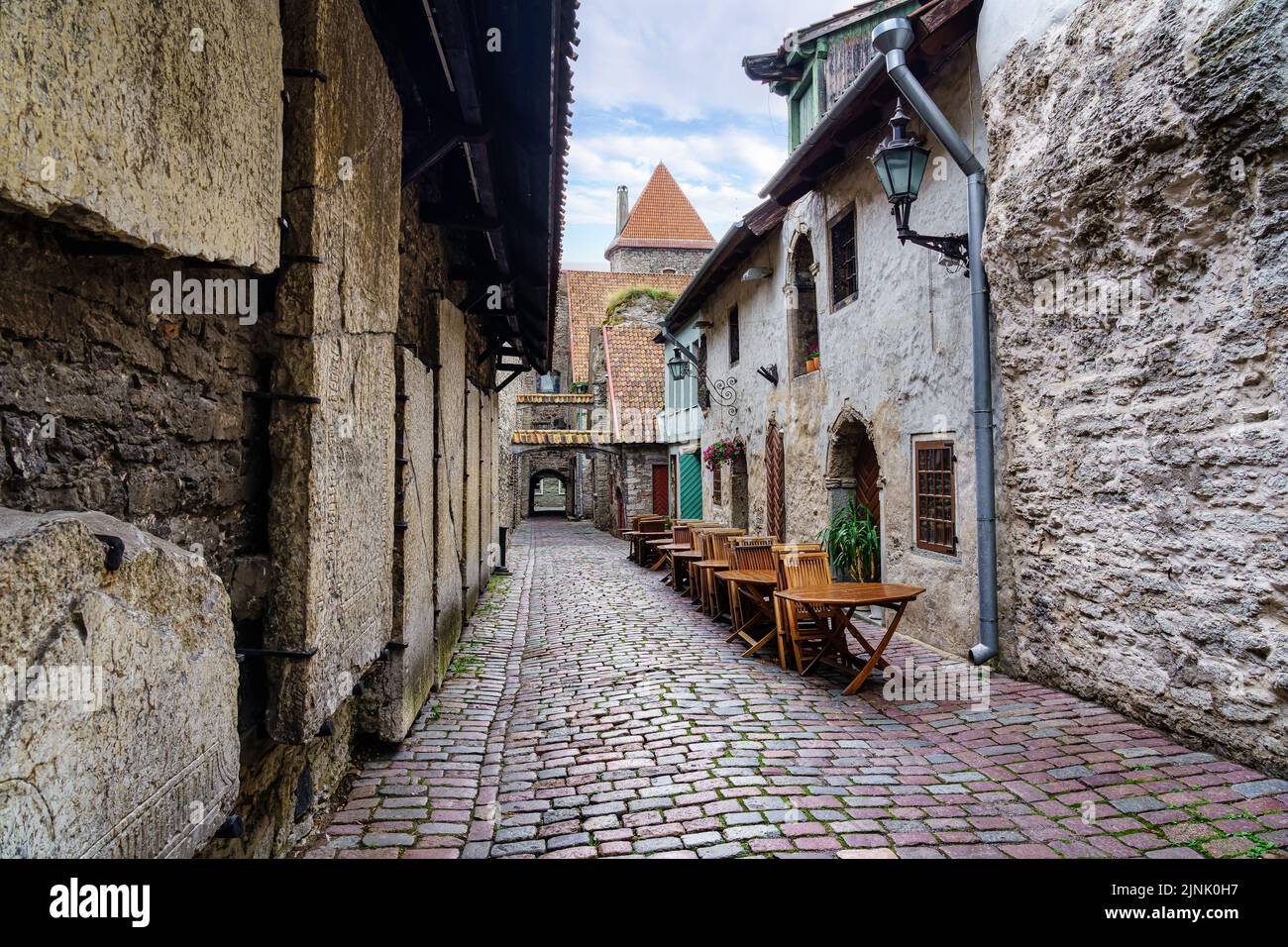 Medieval alley with stone houses and castle tower in Tallinn Estonia ...