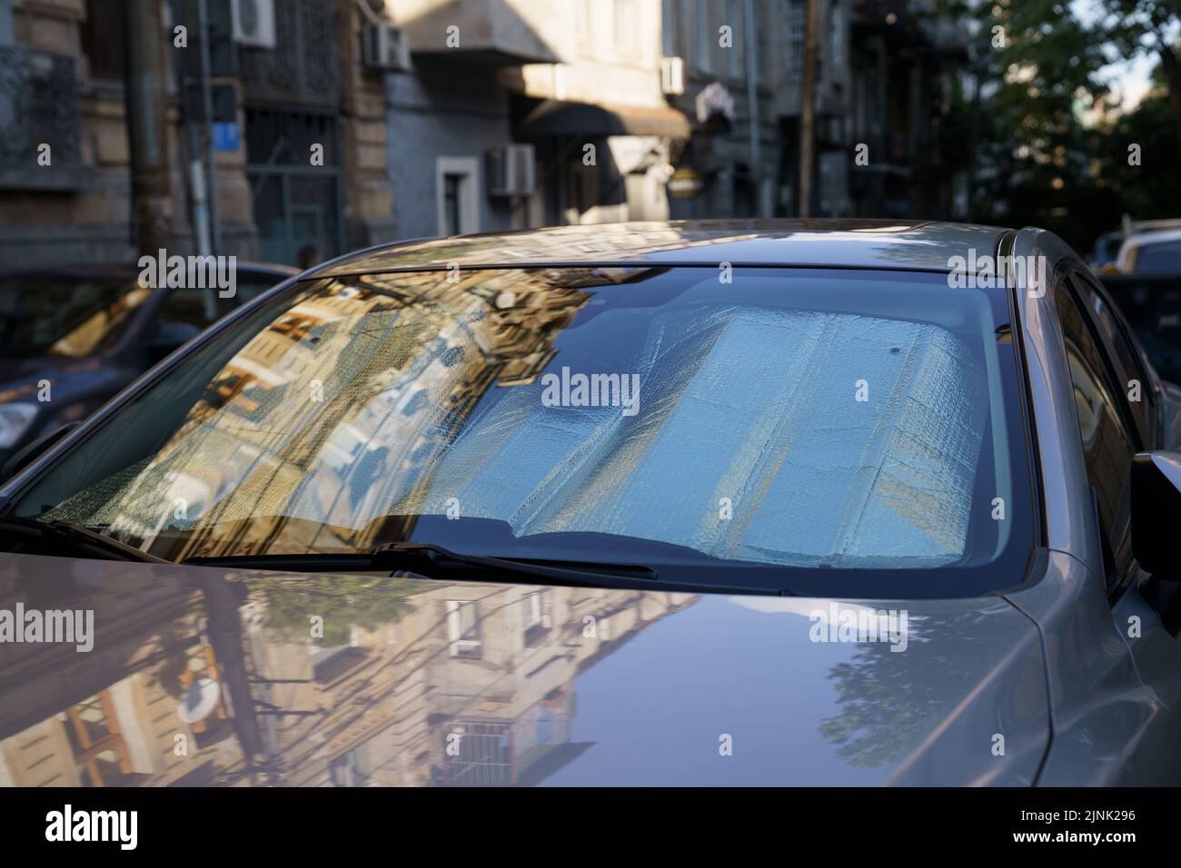 Protective reflective surface under windshield of car on hot day ...