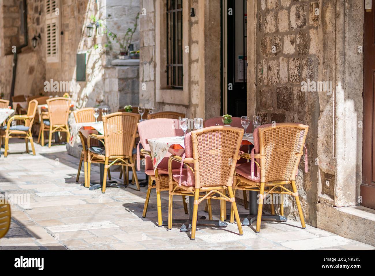 Table and chairs at the restaurant in narrow street are prepared for ...