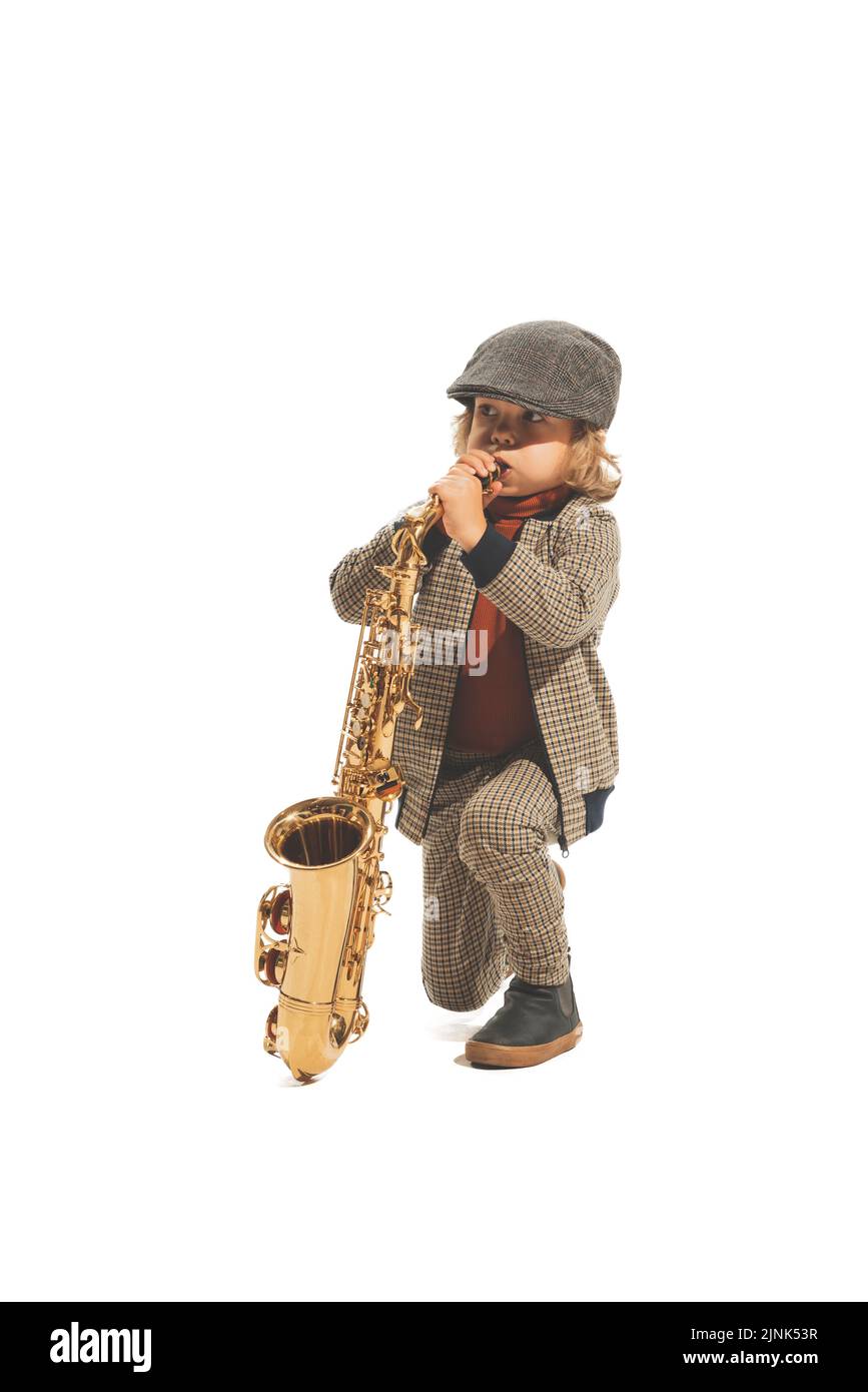Cute happy kid playing saxophone isolated on white studio background ...