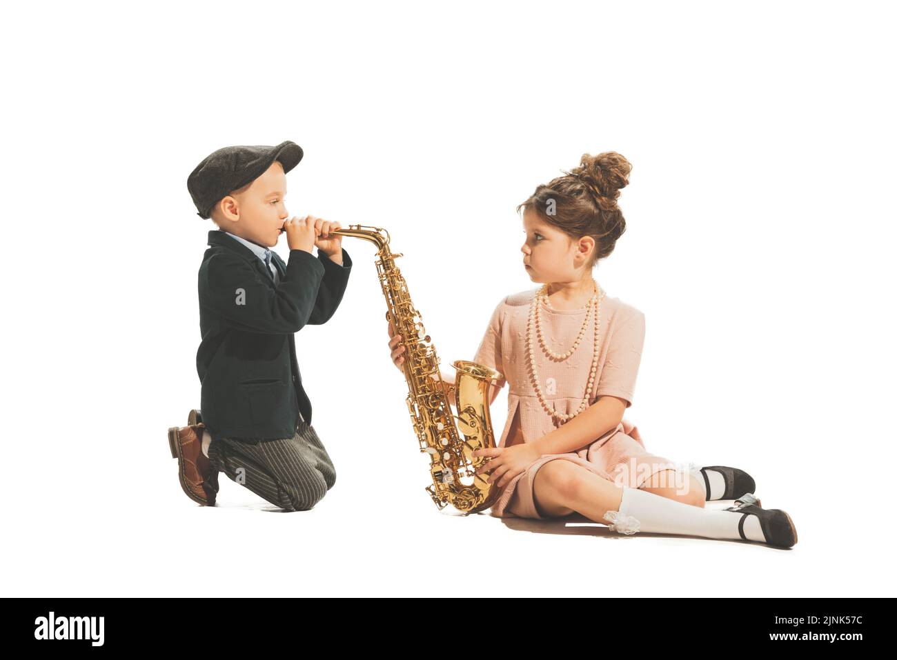 Cute happy kids playing with saxophone isolated on white studio ...