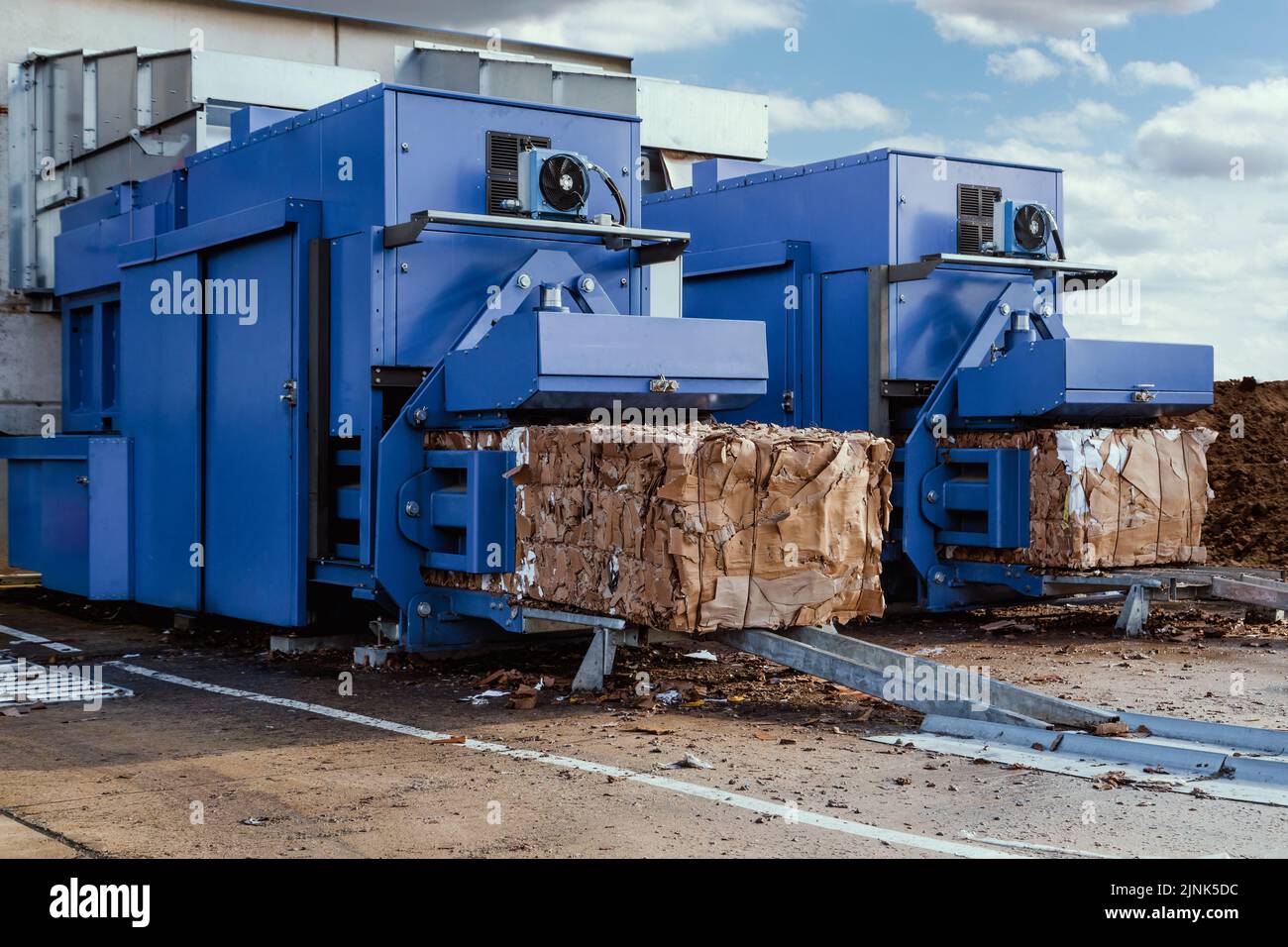 A blue paper squeezer container and a garbage press machine recycle ...