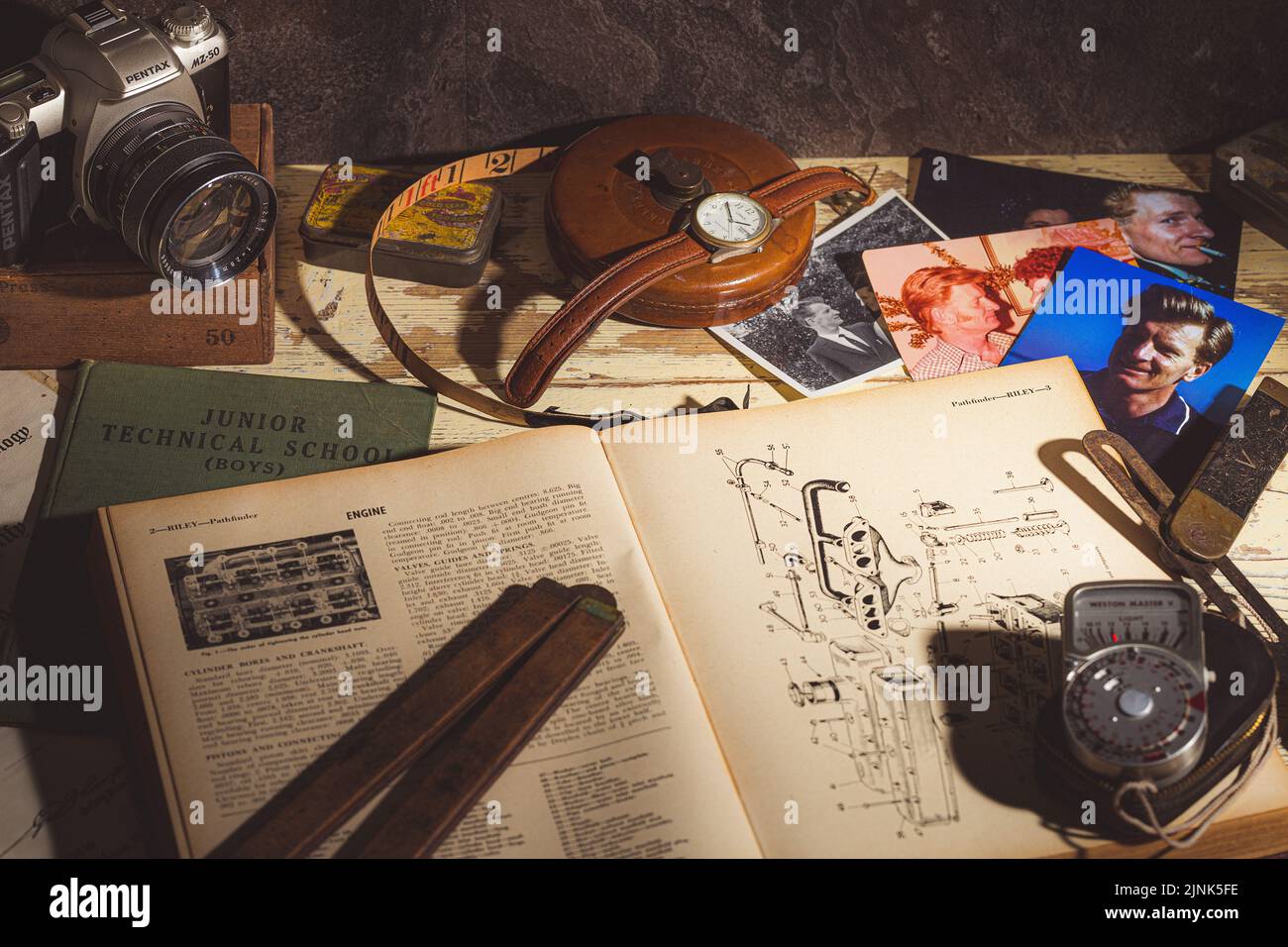A closeup of a messy desk with Engineering book with various objects ...