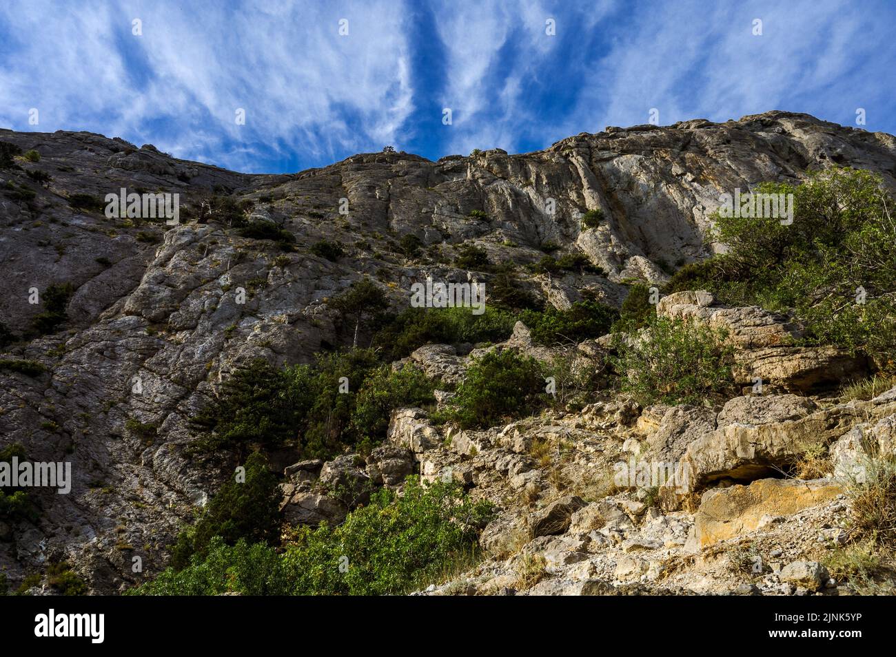 Bottom view of huge rock. Clouds in blue sea. Mountain Stock Photo - Alamy