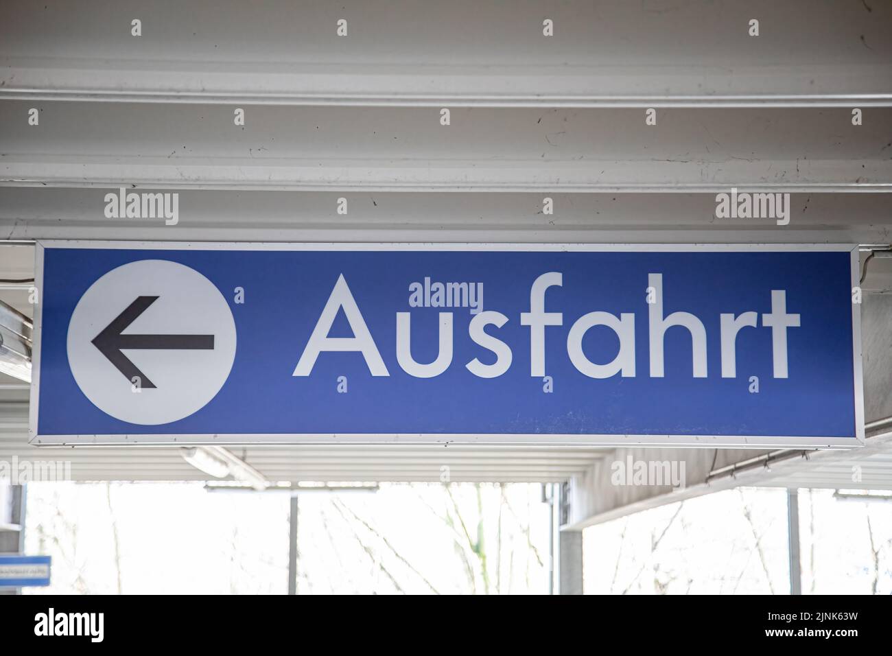A closeup of an exit sign in german with an arrow and hanging on the ...