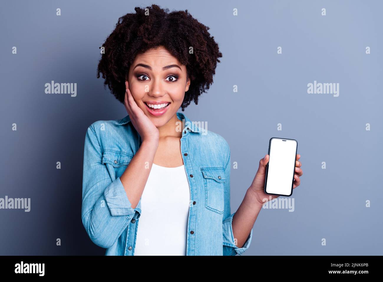 Portrait of funny positive girl arm touch cheek hold demonstrate empty ...