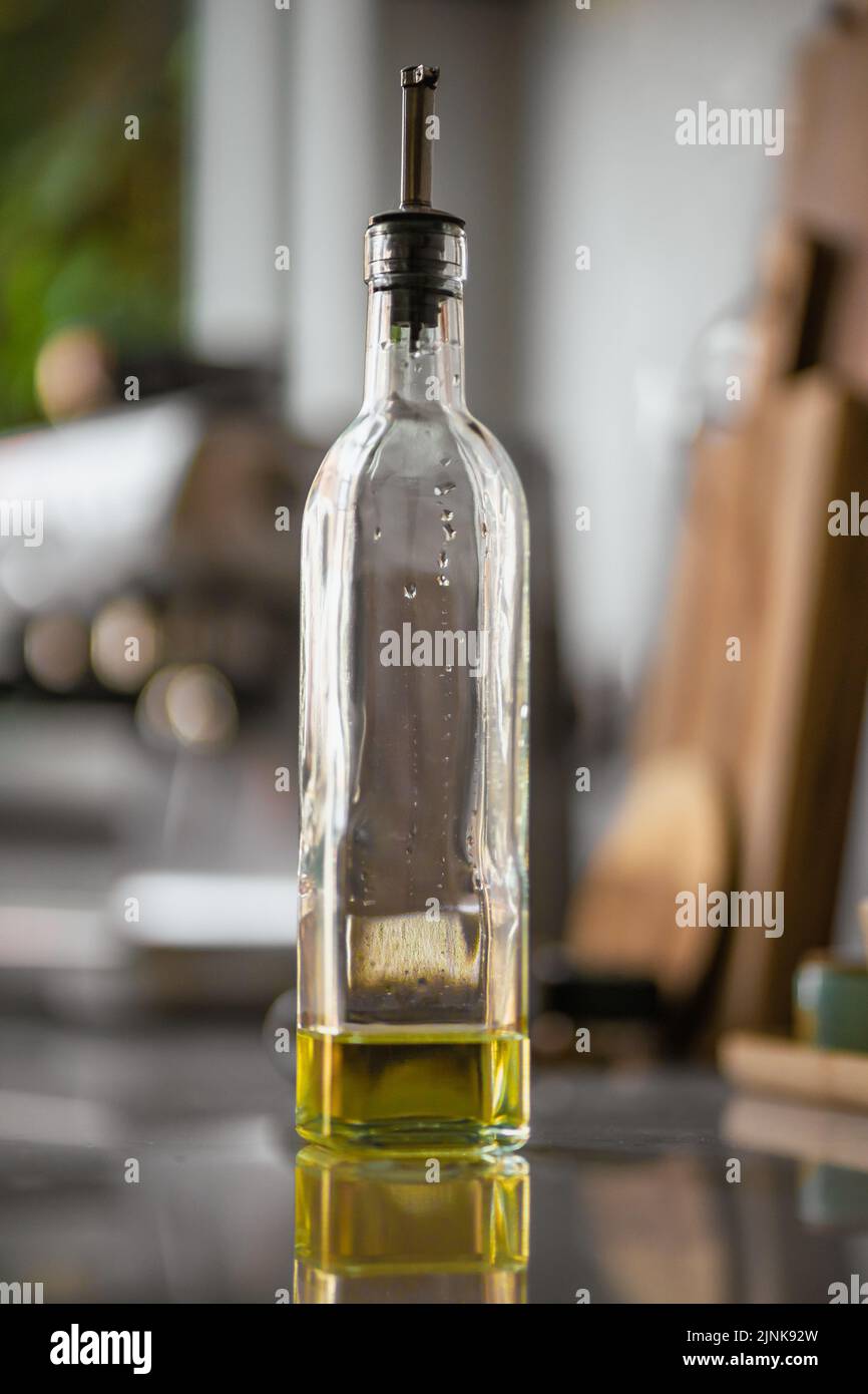 A vertical closeup of an almost empty bottle with extra virgin olive ...