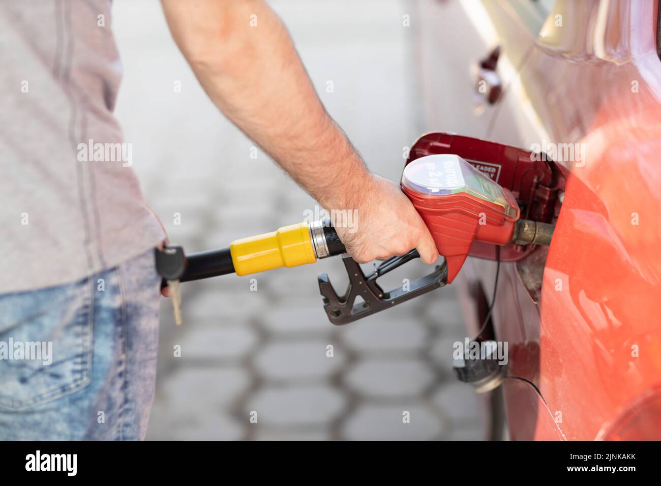 Man filling fuel tank in his hand at gas station Stock Photo - Alamy