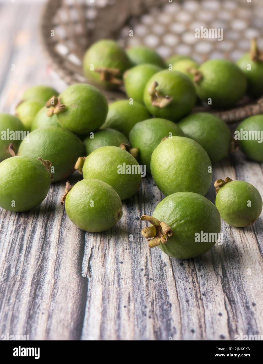 wild guava fruits scattered on a wooden surface, freshly harvested ...
