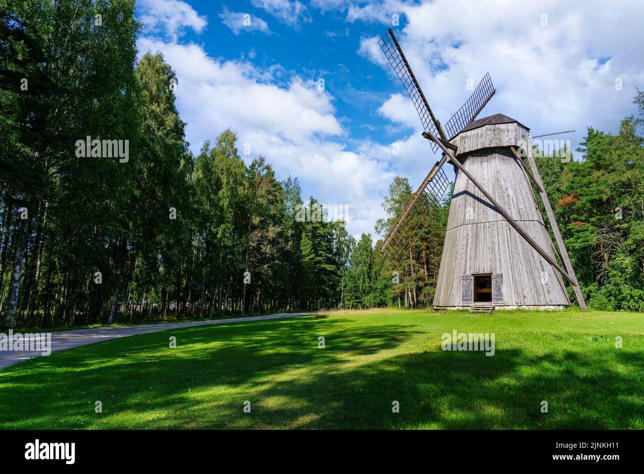 Old wooden windmill over meadow and cloudy sky Stock Photo - Alamy